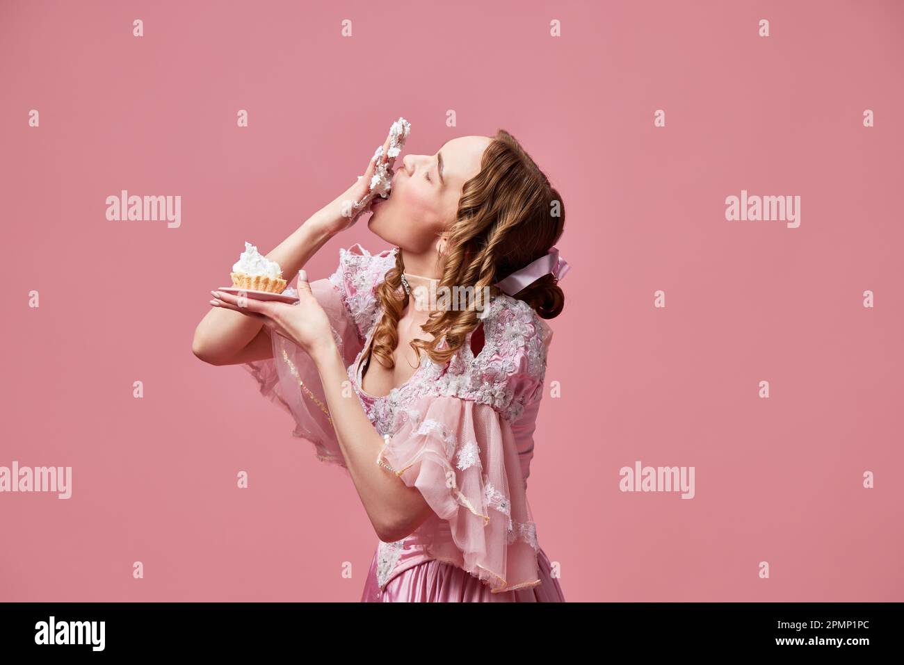 Hungry fairy tale blond princess wearing renaissance dress eating ...