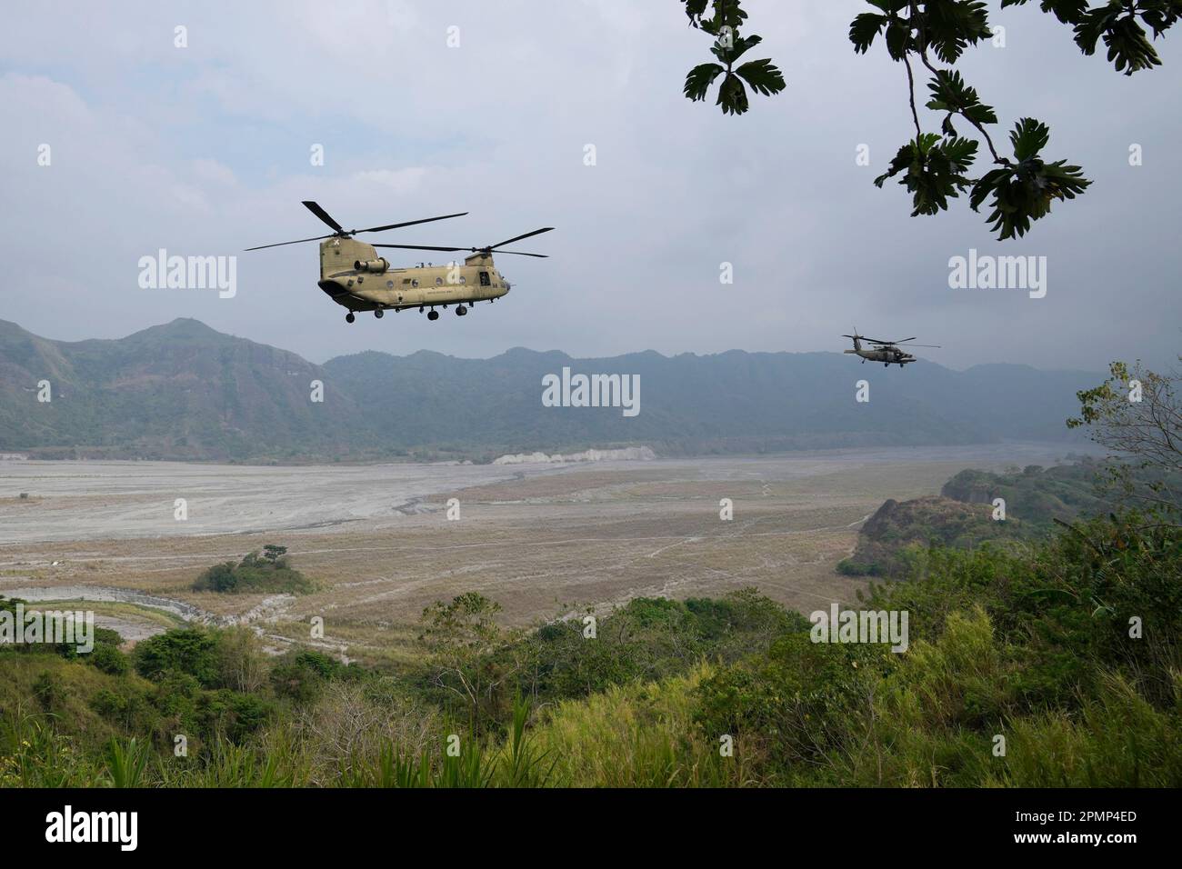 A U.S. Chinook and Black Hawk helicopter perform maneuvers during a ...