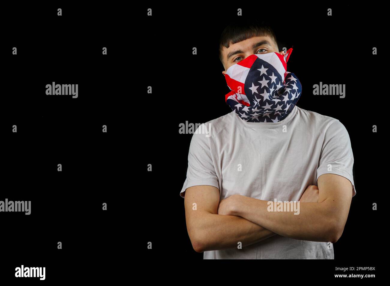 Teenage boy wearing an American flag mask against a black background ...