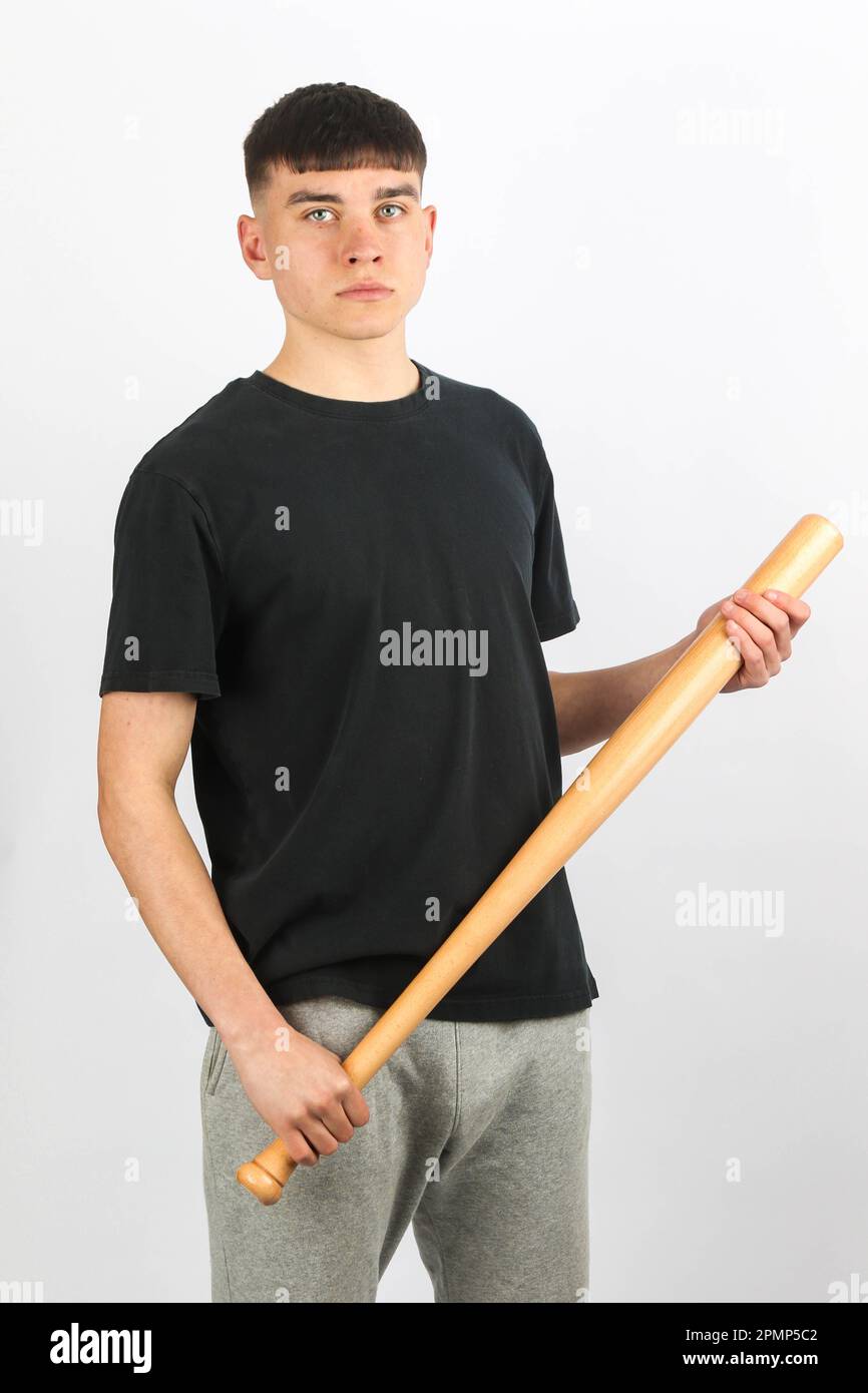 Teenage boy holding a baseball bat against a white background Stock ...