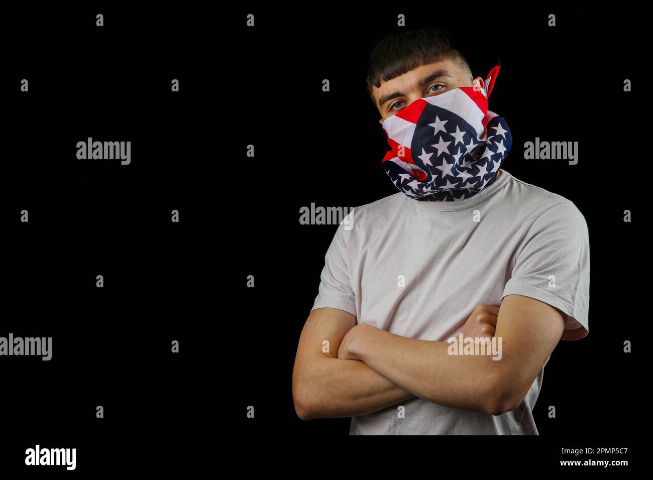 Teenage boy wearing an American flag mask against a black background ...