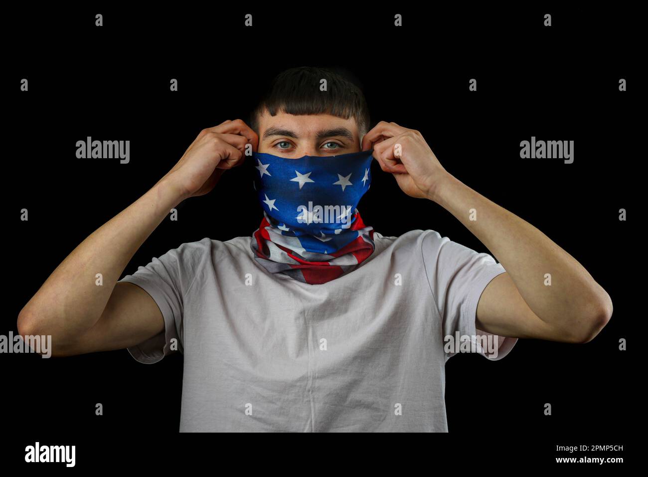 Teenage boy wearing an American flag mask against a black background ...