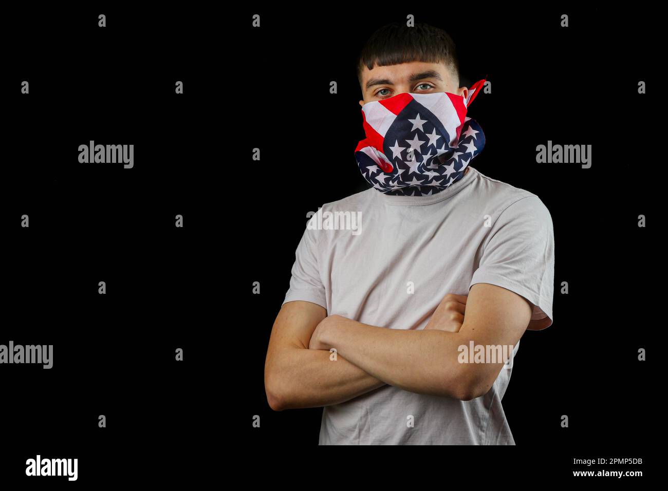 Teenage boy wearing an American flag mask against a black background ...