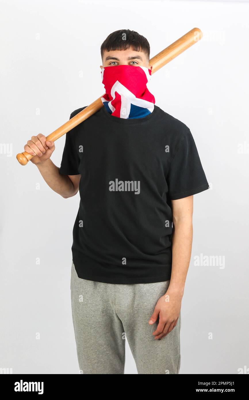 Teenage boy wearing an Union Jack mask holding a baseball bat against a ...