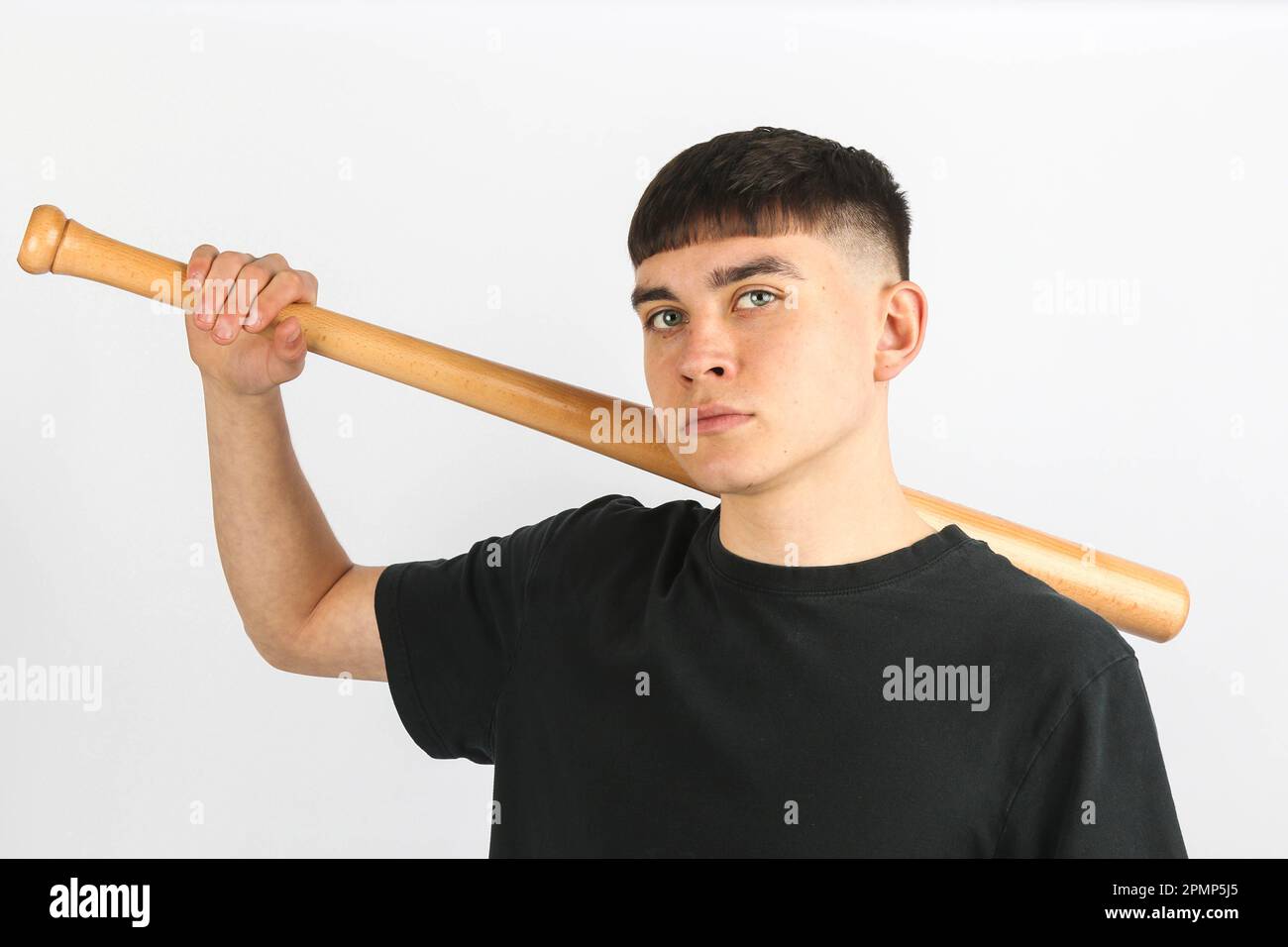 Teenage boy holding a baseball bat against a white background Stock ...