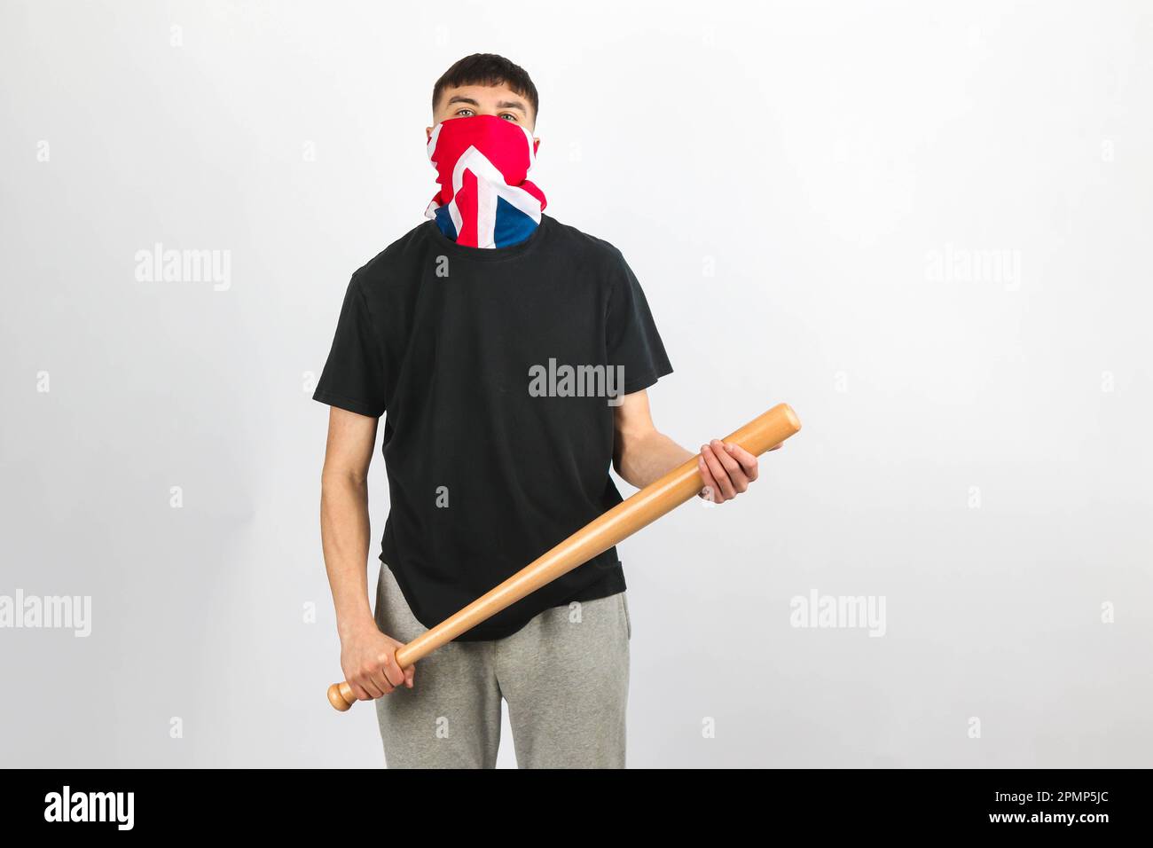 Teenage boy wearing an Union Jack mask holding a baseball bat against a ...