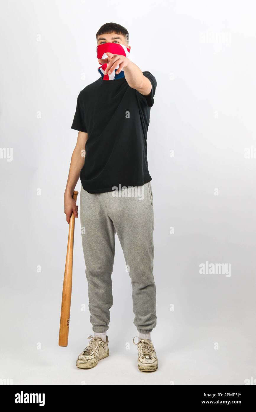 Teenage boy wearing an Union Jack mask holding a baseball bat against a ...