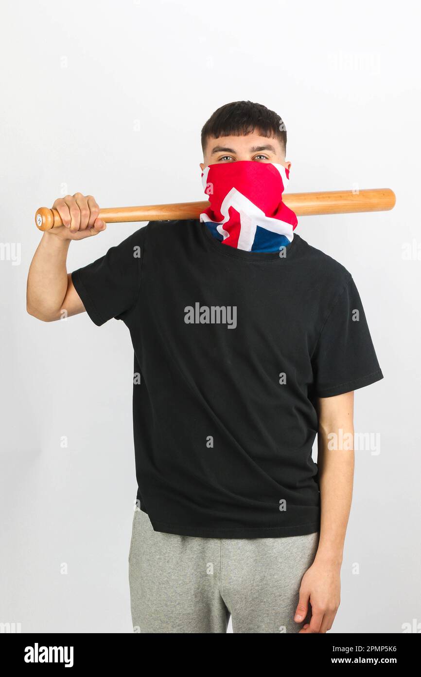 Teenage boy wearing an Union Jack mask holding a baseball bat against a ...
