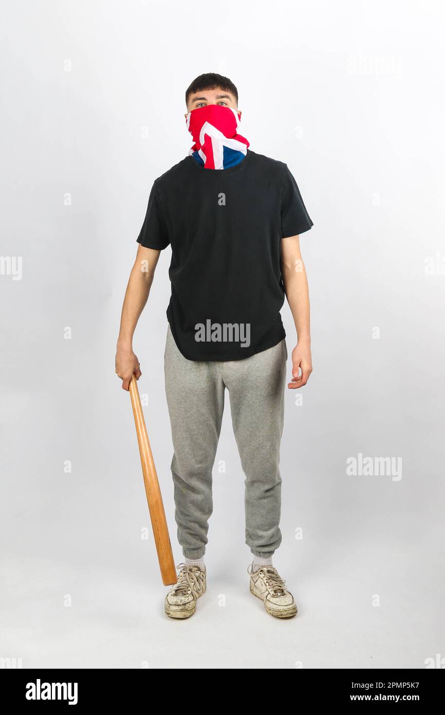 Teenage boy wearing an Union Jack mask holding a baseball bat against a ...