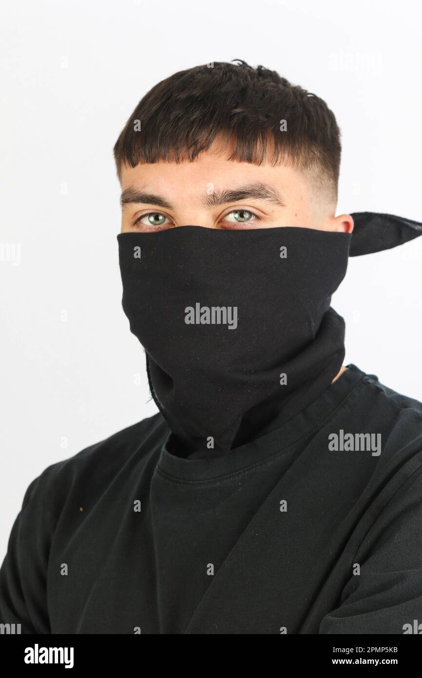 Teenage boy wearing a black mask against a white background Stock Photo ...