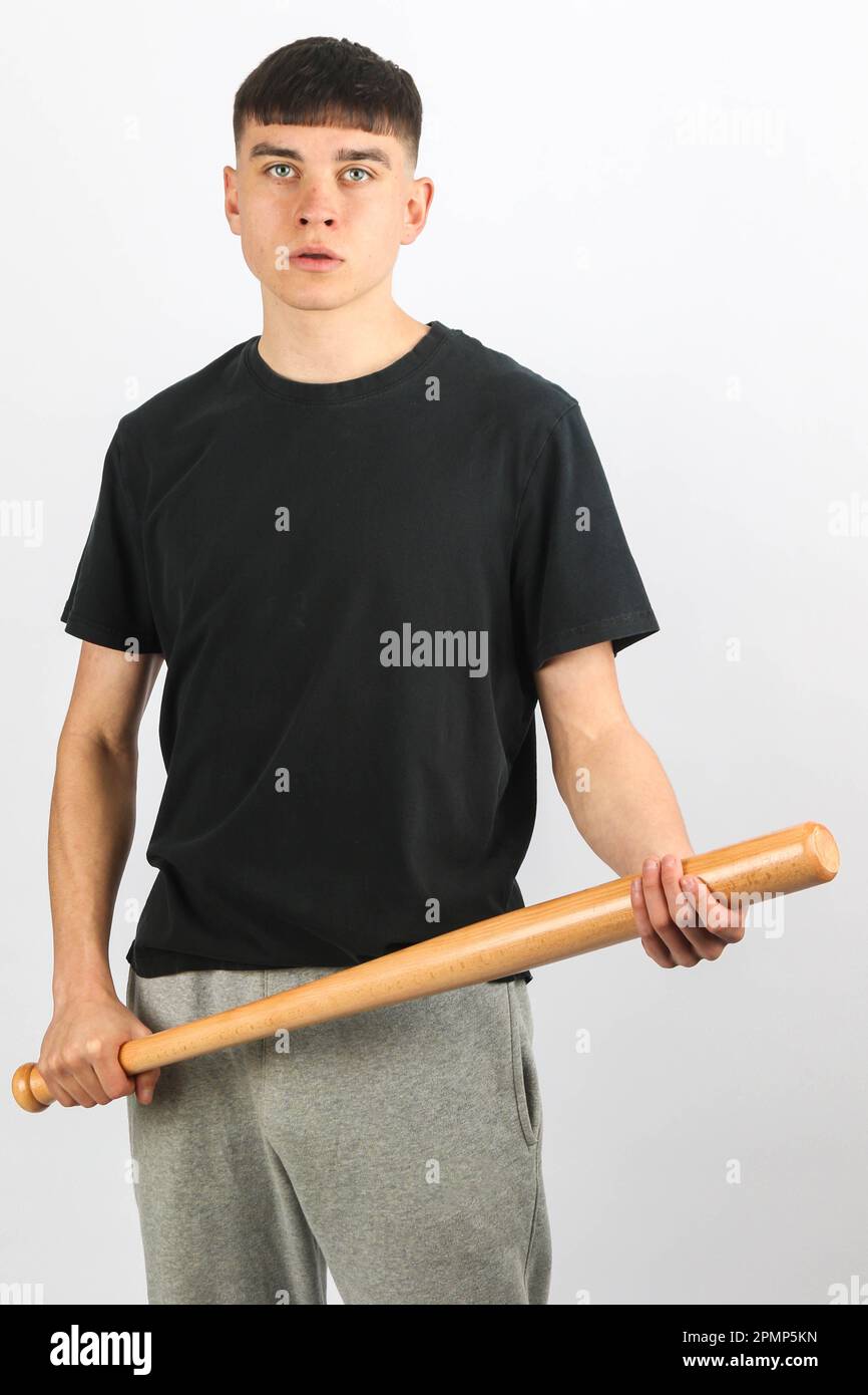 Teenage boy holding a baseball bat against a white background Stock ...