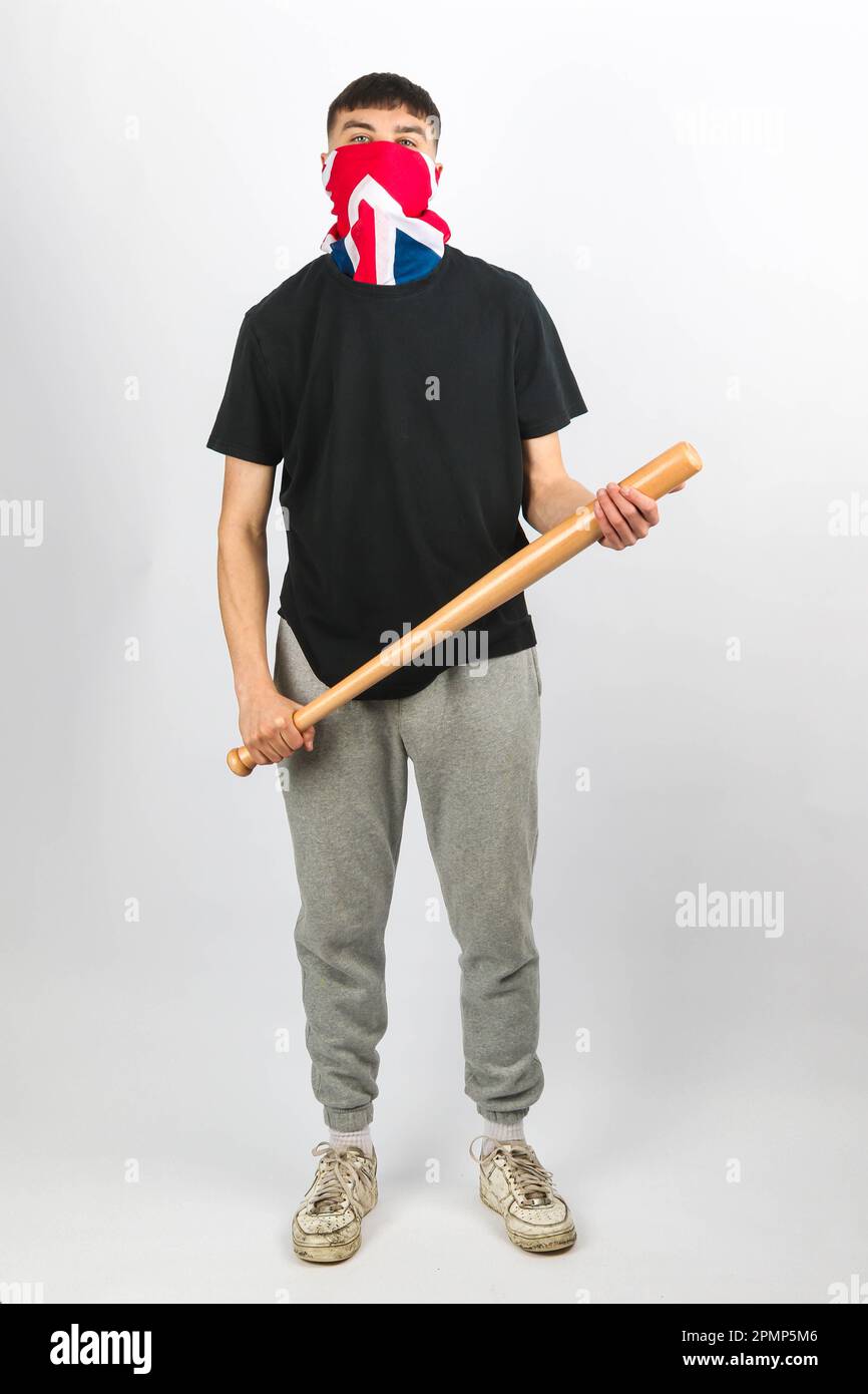 Teenage boy wearing an Union Jack mask holding a baseball bat against a ...