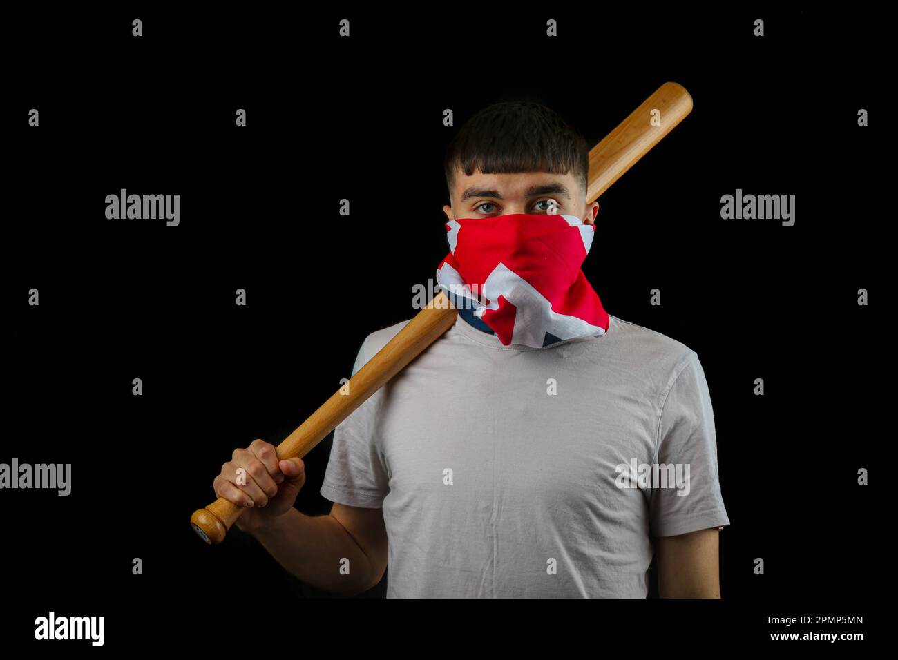 Teenage boy wearing an British flag mask holding a baseball bat against ...