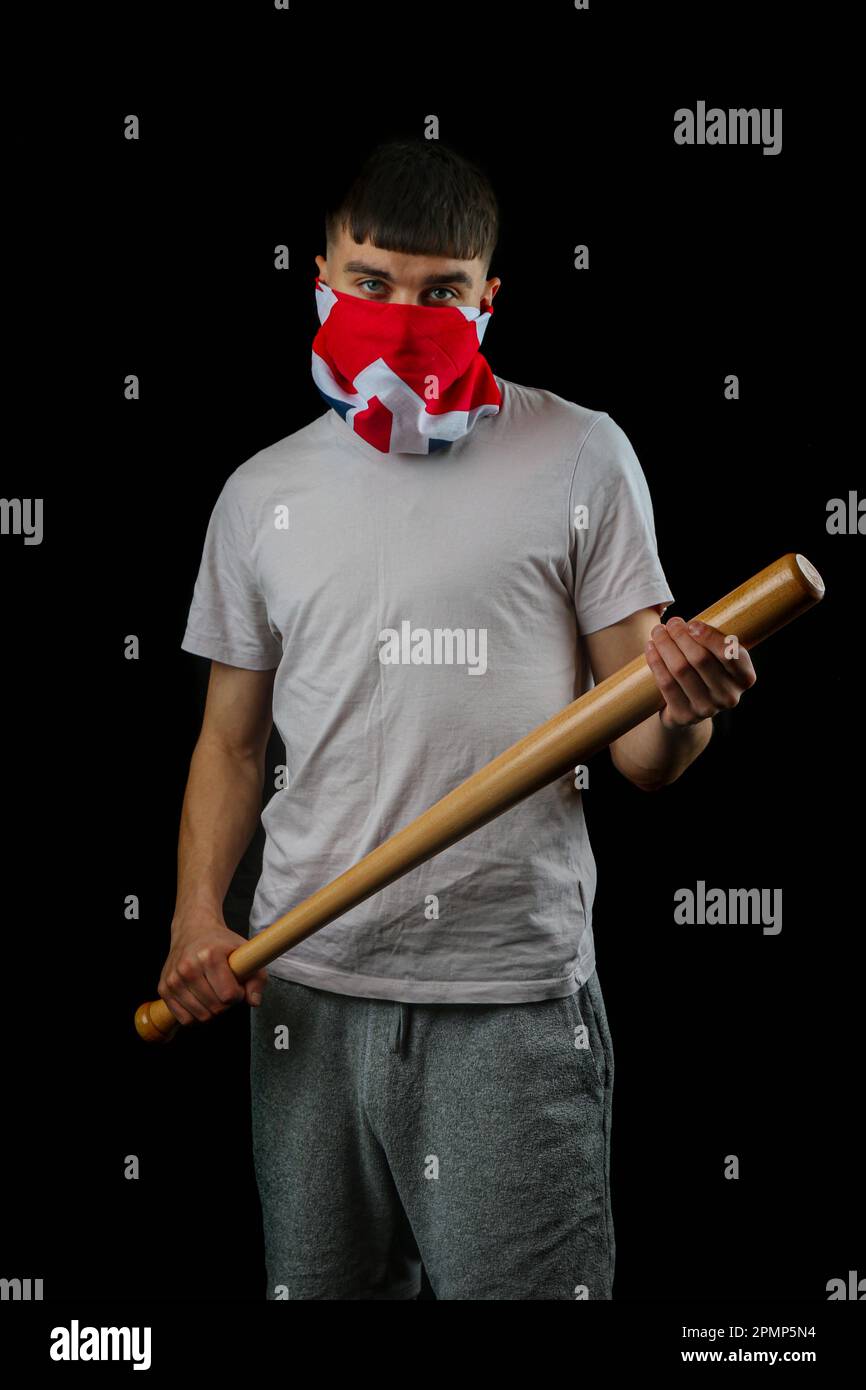 Teenage boy wearing an British flag mask holding a baseball bat against ...