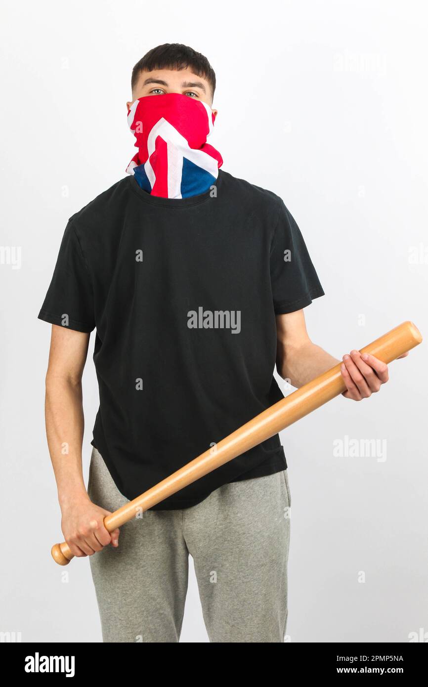 Teenage boy wearing an Union Jack mask holding a baseball bat against a ...