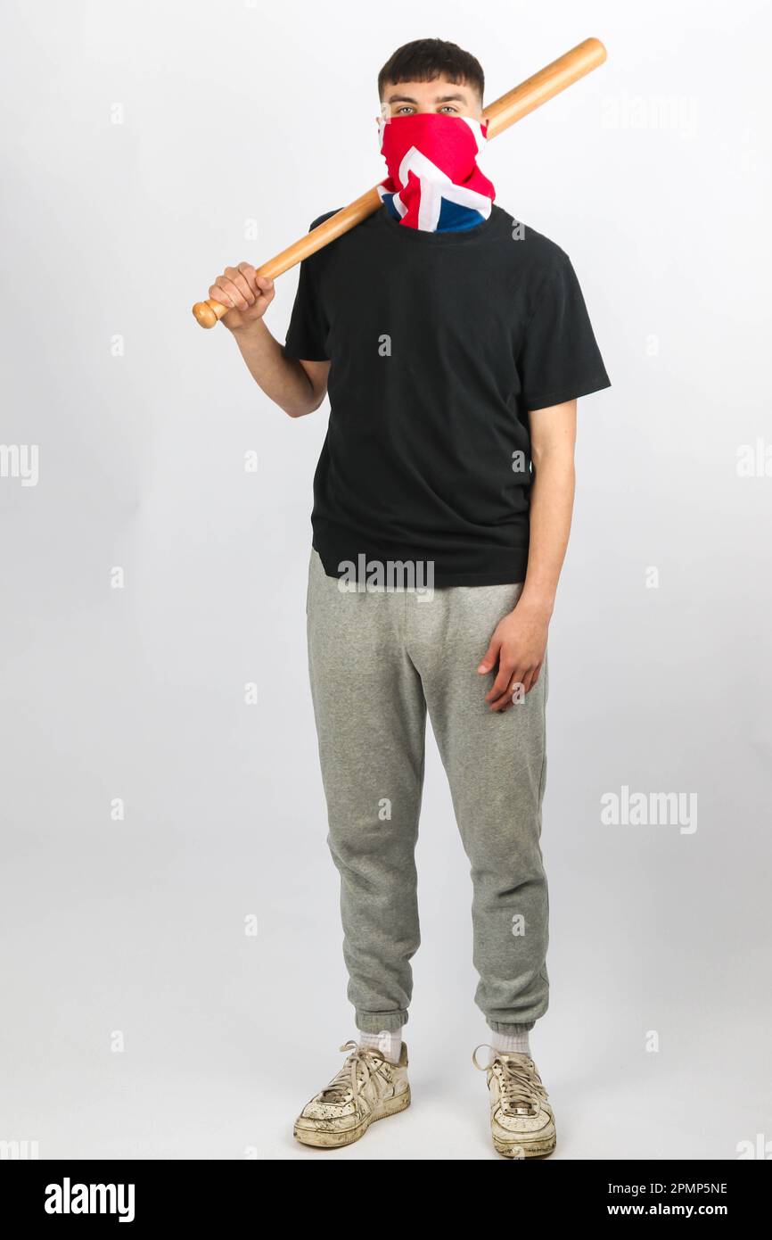 Teenage boy wearing an Union Jack mask holding a baseball bat against a ...