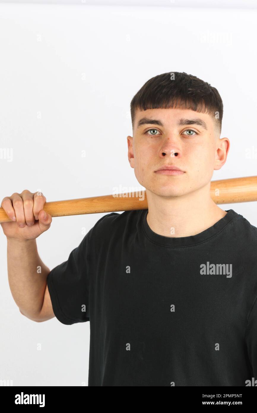 Teenage boy holding a baseball bat against a white background Stock ...
