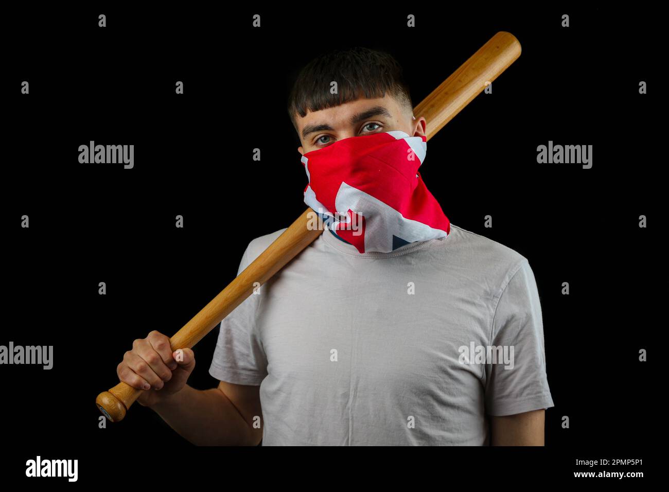 Teenage boy wearing an British flag mask holding a baseball bat against ...