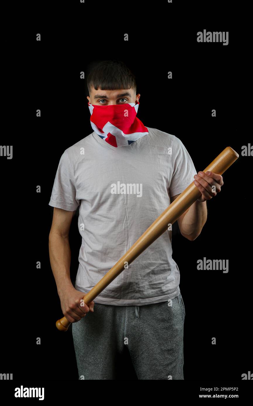 Teenage boy wearing an British flag mask holding a baseball bat against ...