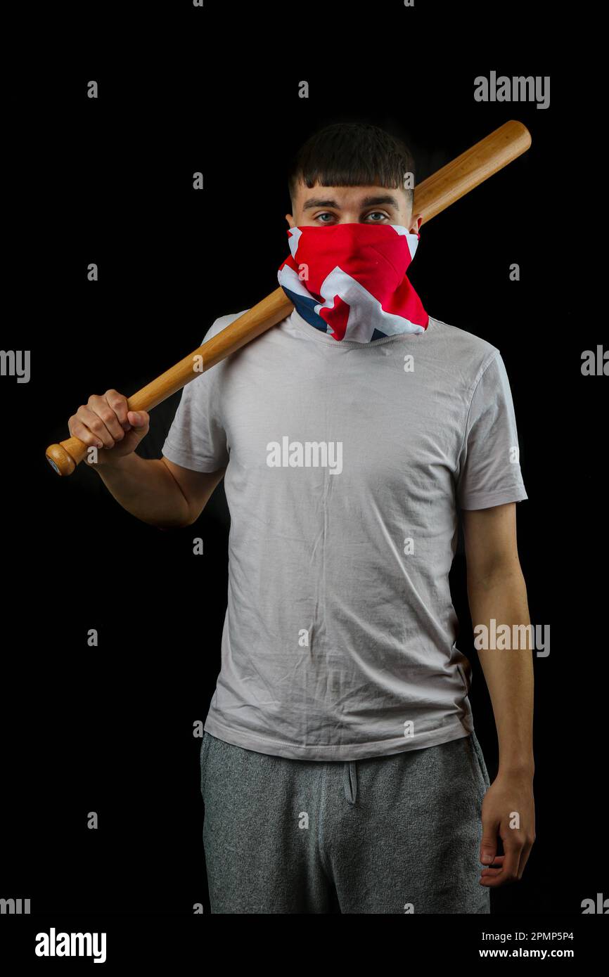 Teenage boy wearing an British flag mask holding a baseball bat against ...