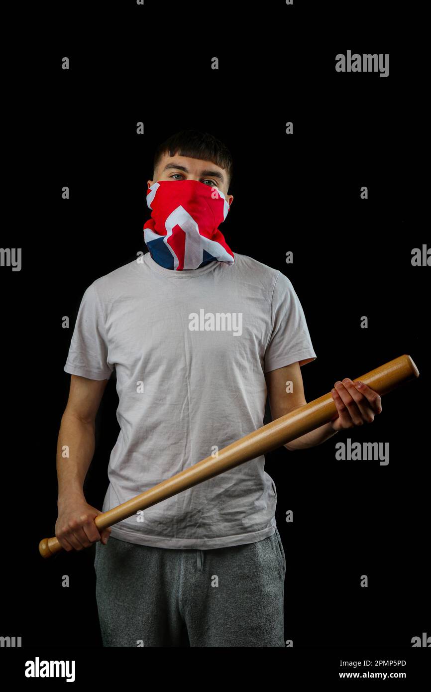 Teenage boy wearing an British flag mask holding a baseball bat against ...