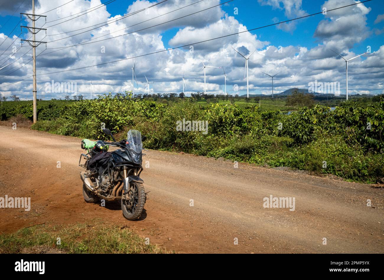 A large black motorcycle parked on a dirt track next to a power ...