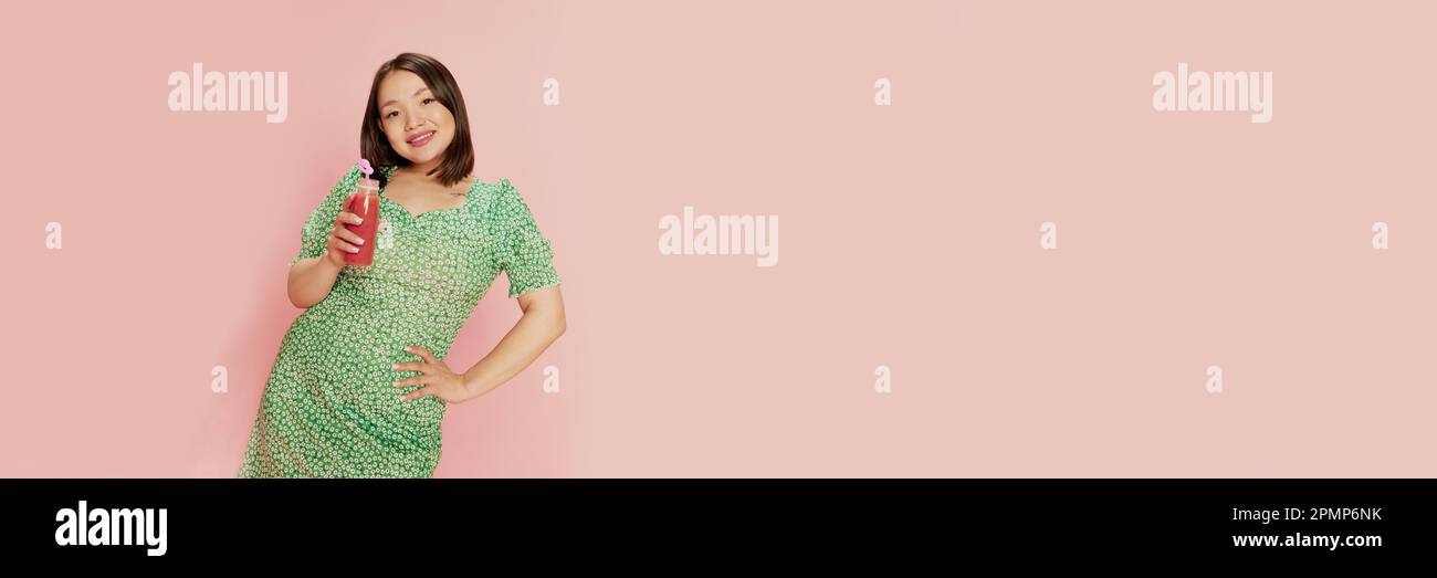 Portrait of beautiful, smiling, young girl drinking coke, posing in ...