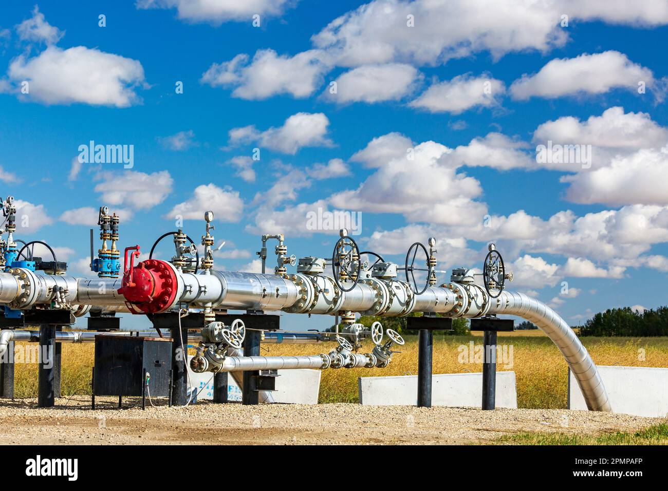 Oil pipeline with values, blue sky and clouds, West of Airdrie; Alberta ...