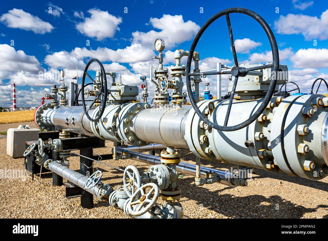 Oil pipeline with values, blue sky and clouds, West of Airdrie; Alberta ...