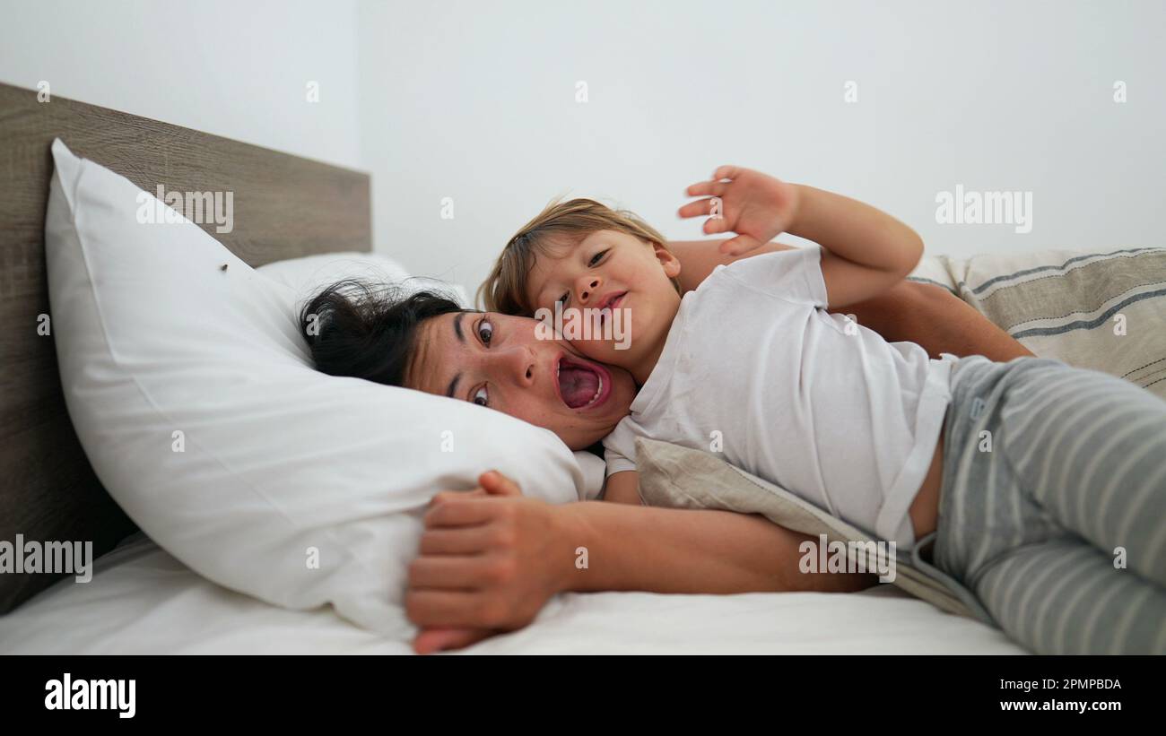Mother and child laying in bed smiling. Happiness motherhood lifestyle ...