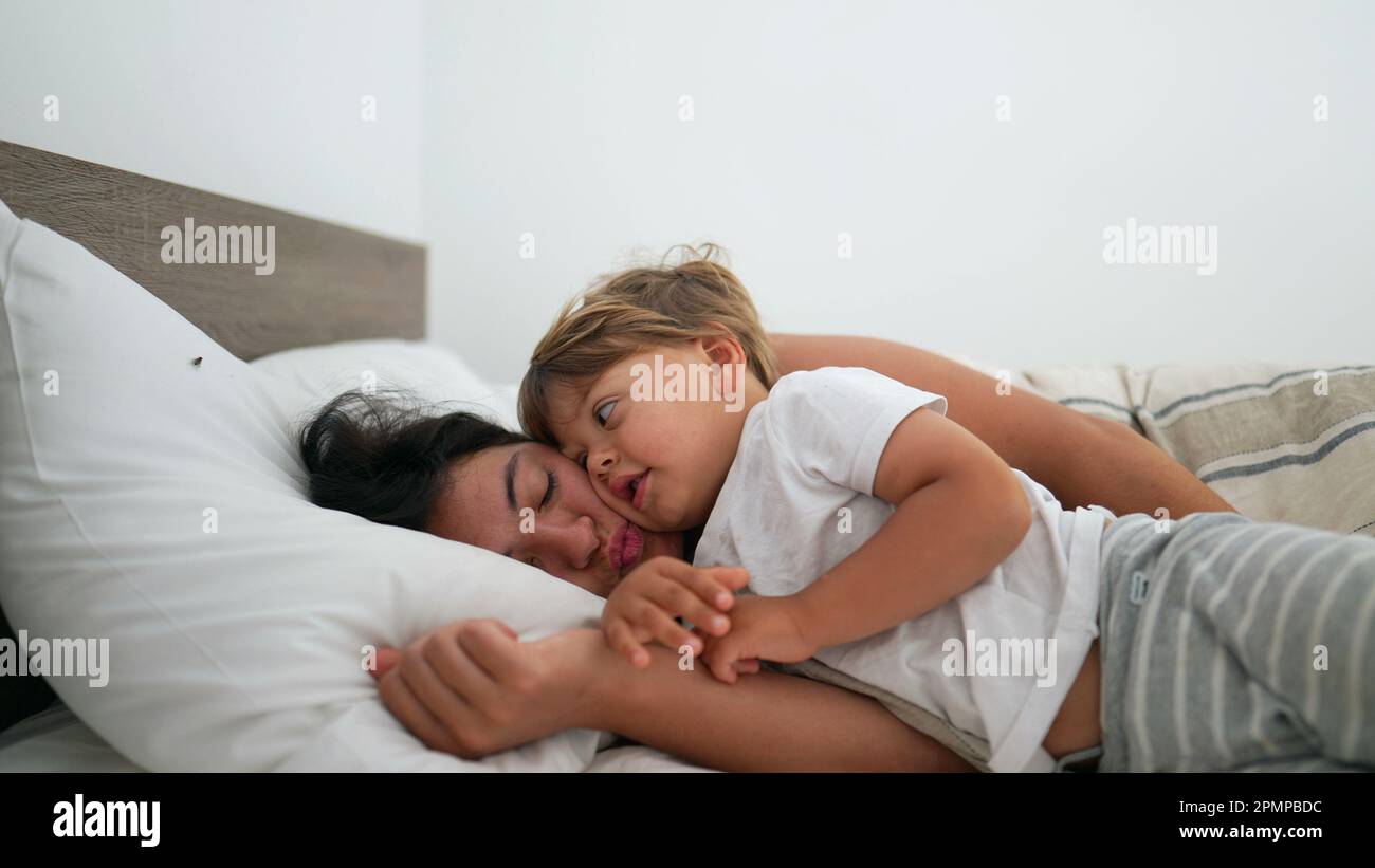 Mother and child laying in bed smiling. Happiness motherhood lifestyle ...