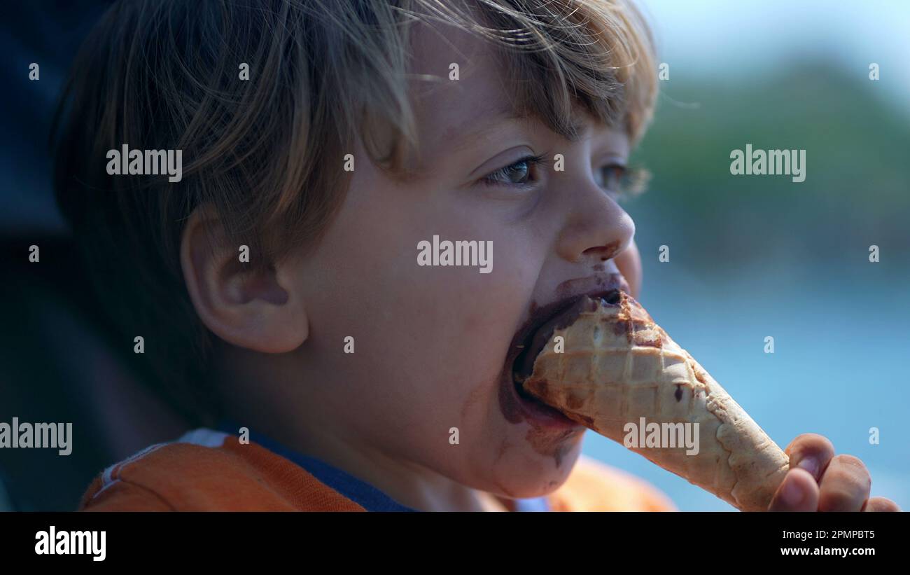 Child eating ice cream cone snack. Kid portrait face eats dessert Stock ...