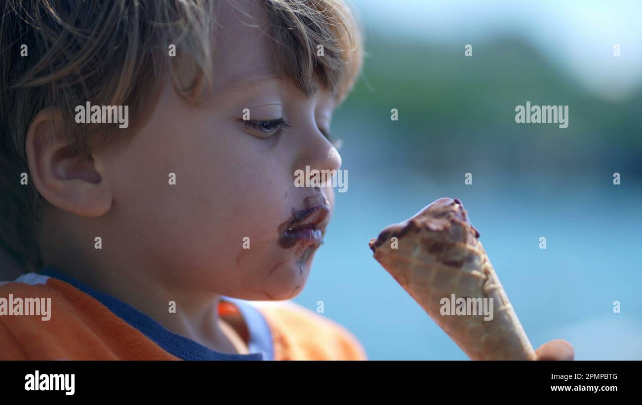 Child eating ice cream cone snack. Kid portrait face eats dessert Stock ...