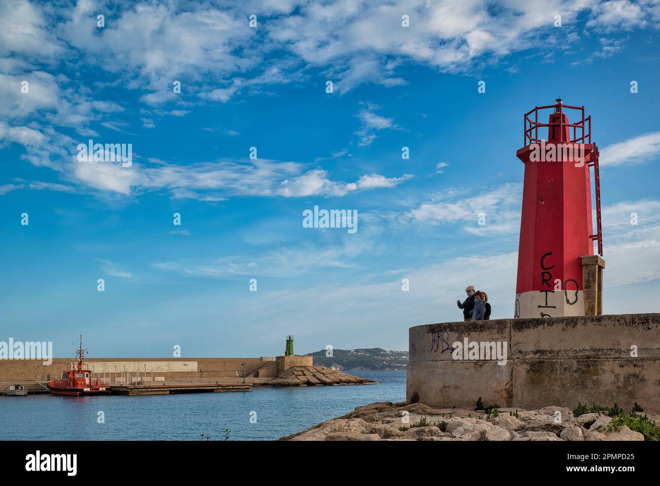 people walking along the north breakwater, red and green lighthouse in ...