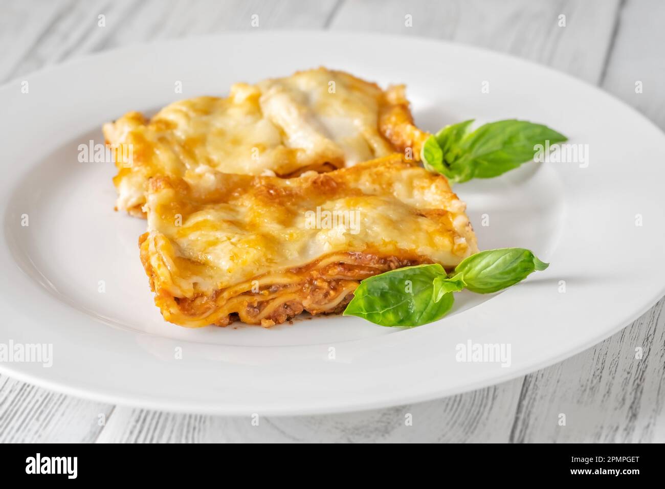Portion of traditional lasagna with basil leaves Stock Photo - Alamy