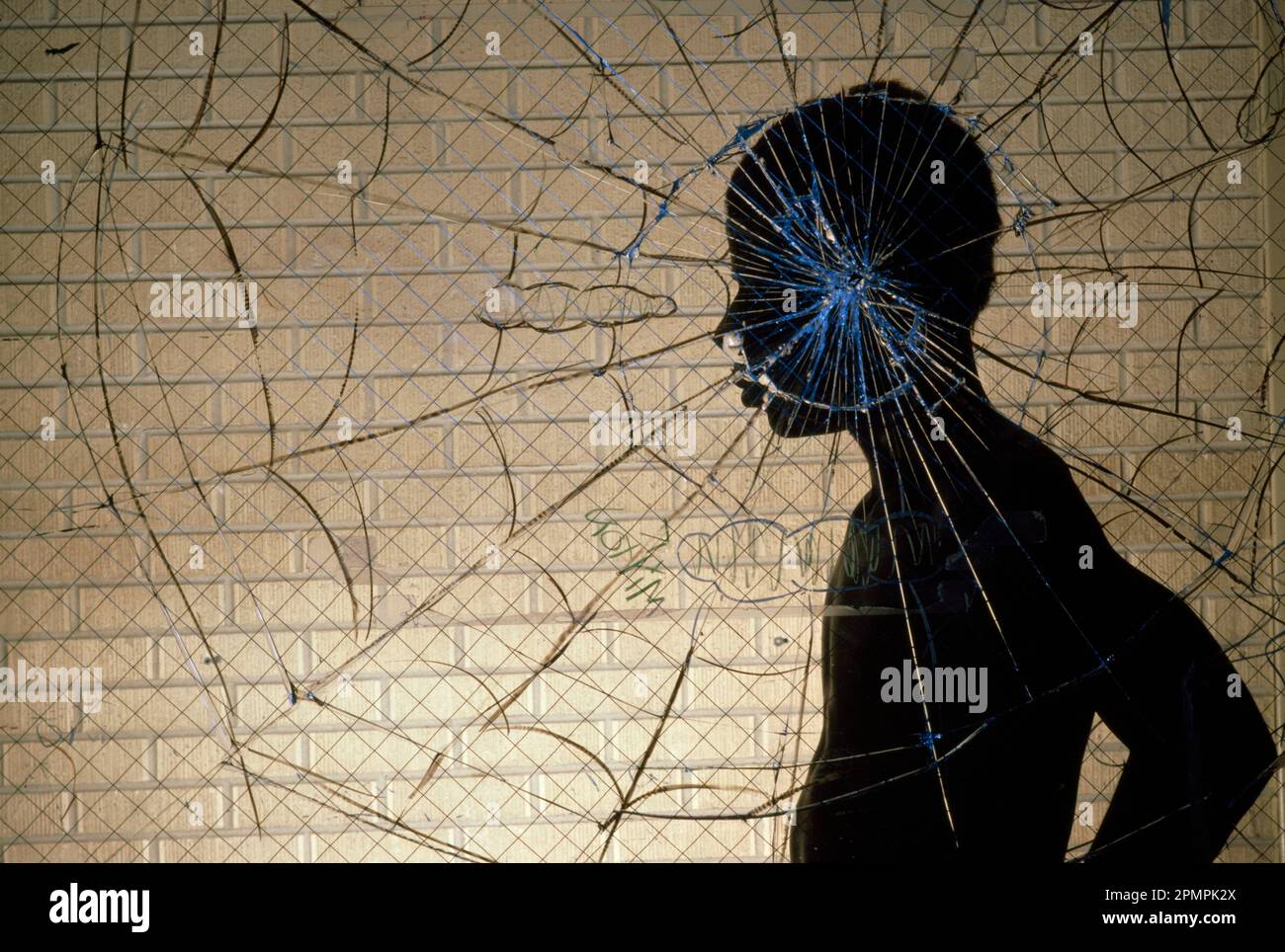 Silhouette of a boy behind broken glass at a detention center; Denver ...