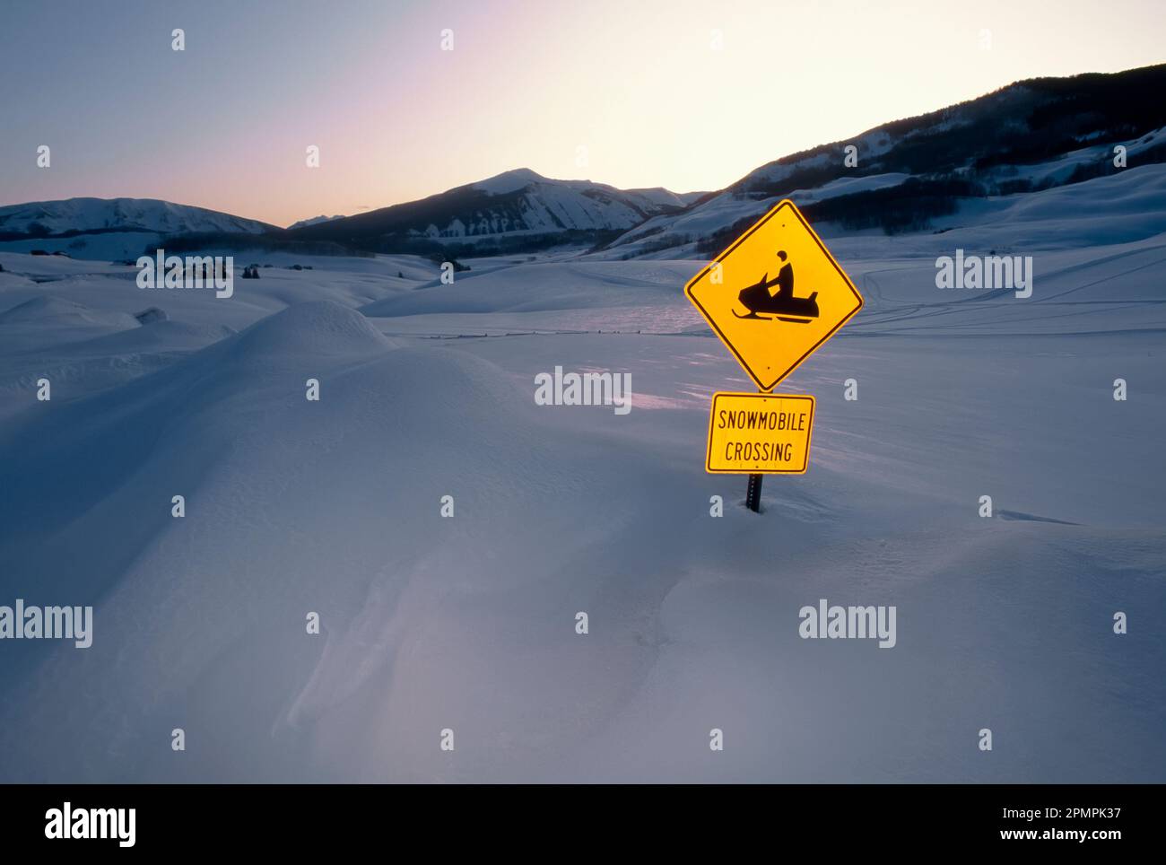 'Snowmobile Crossing' sign in a snowdrift; Crested Butte, Colorado ...