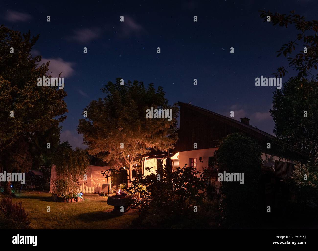 A cozy suburban home illuminated by a soft navy blue hue against the ...