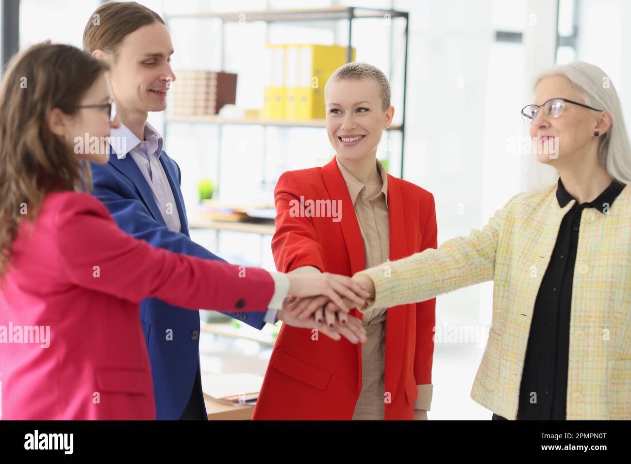 Happy colleagues make unity gesture putting hands together Stock Photo ...