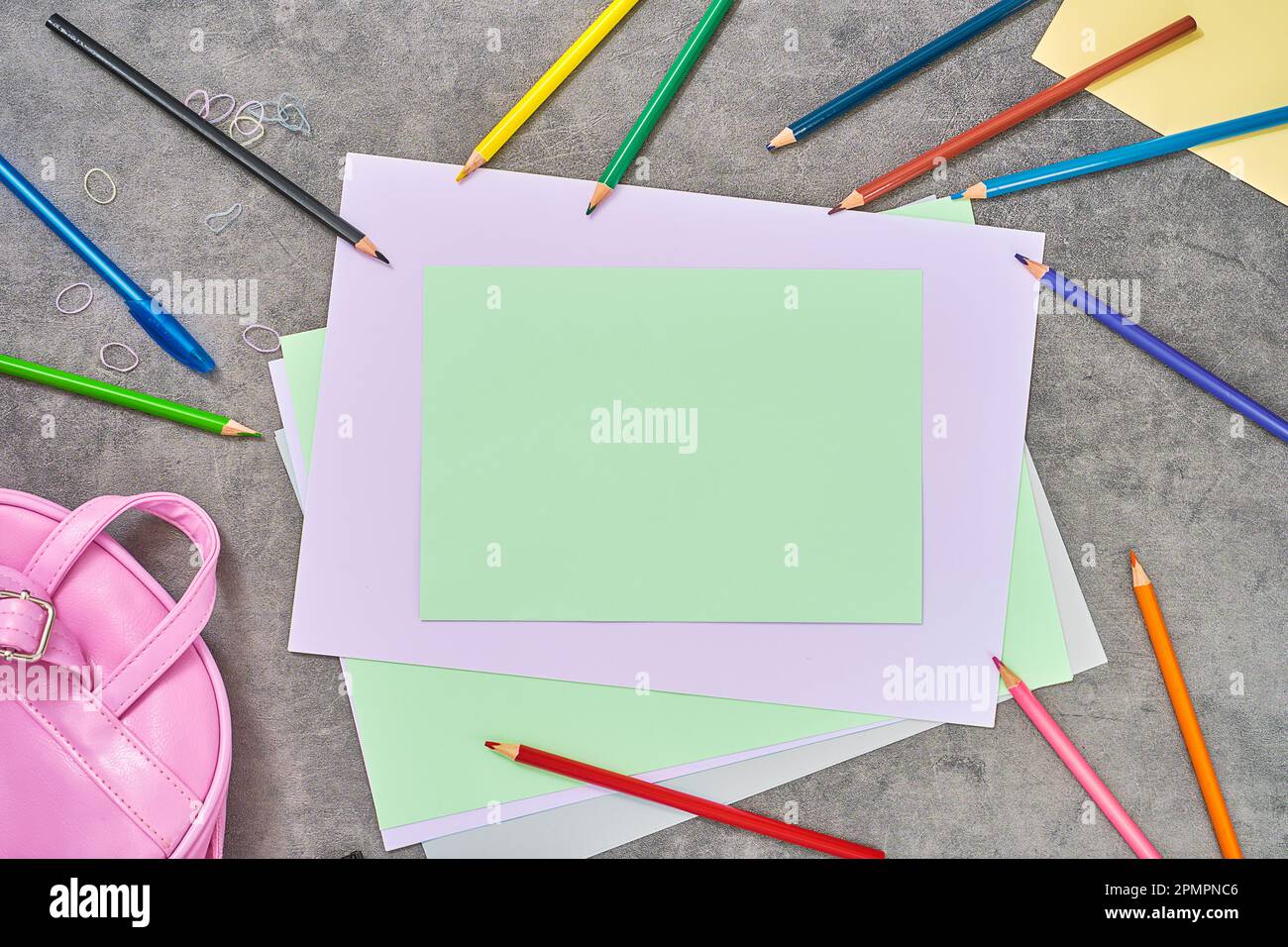 Colored paper and pencils on a light gray background. Education concept ...