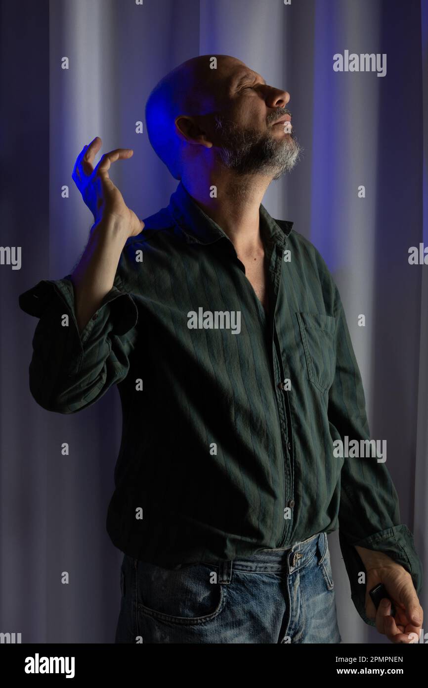 Man standing, worried and thoughtful. Studio portrait. white curtain ...