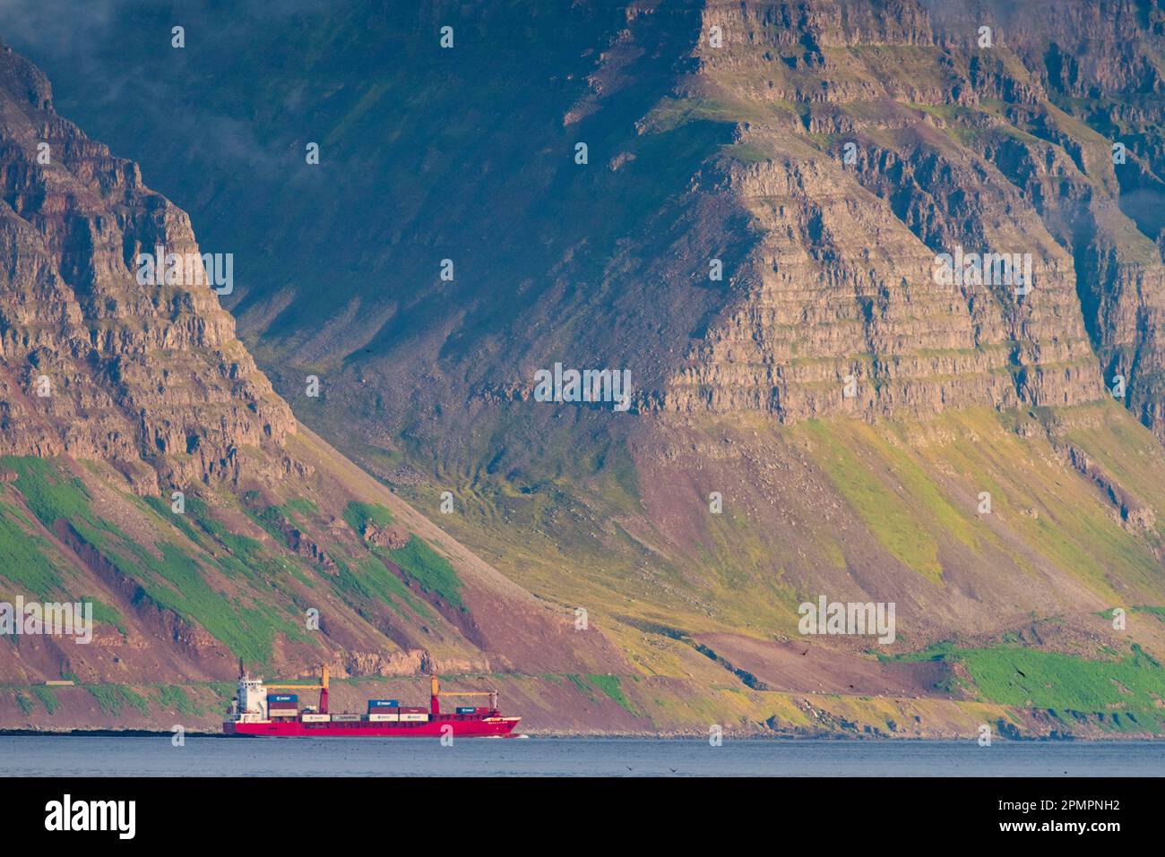 Container ship leaving the port of Isafjorour on the north coast of ...