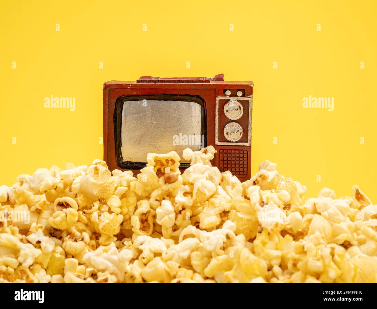 Popcorn and old TV on a yellow background. Sweet popcorn on yellow ...