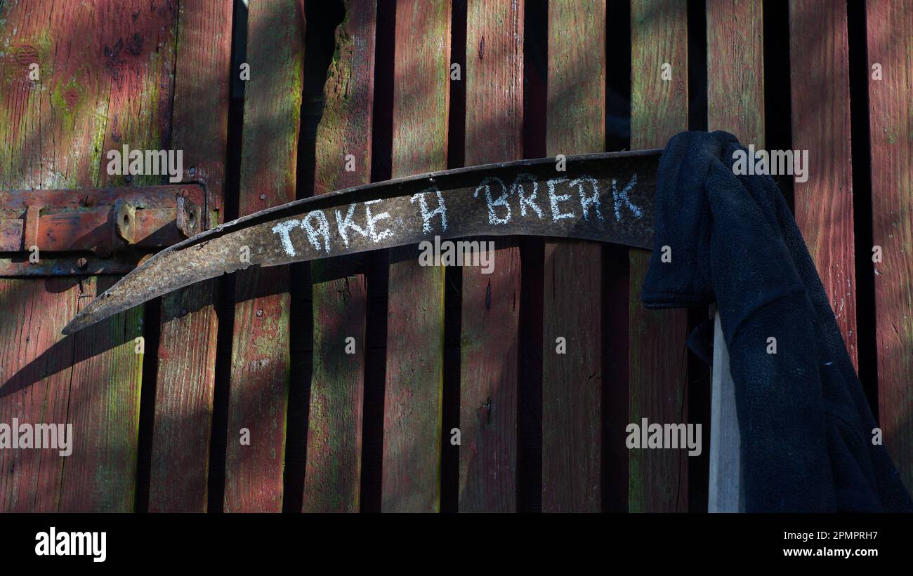 A.scythe with the words "Take a break" written on it. Symbol for death ...