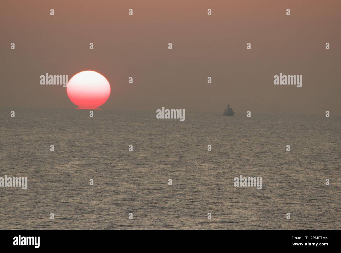 Sunset at sea with a yacht in the foreground Stock Photo - Alamy