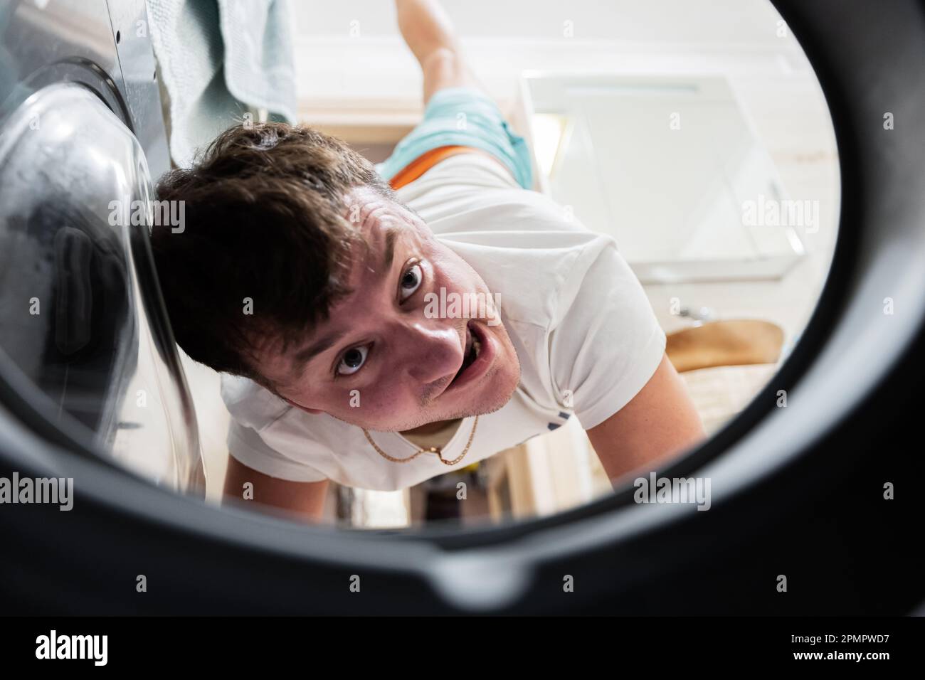 Man view from washing machine inside. Male does laundry daily routine ...