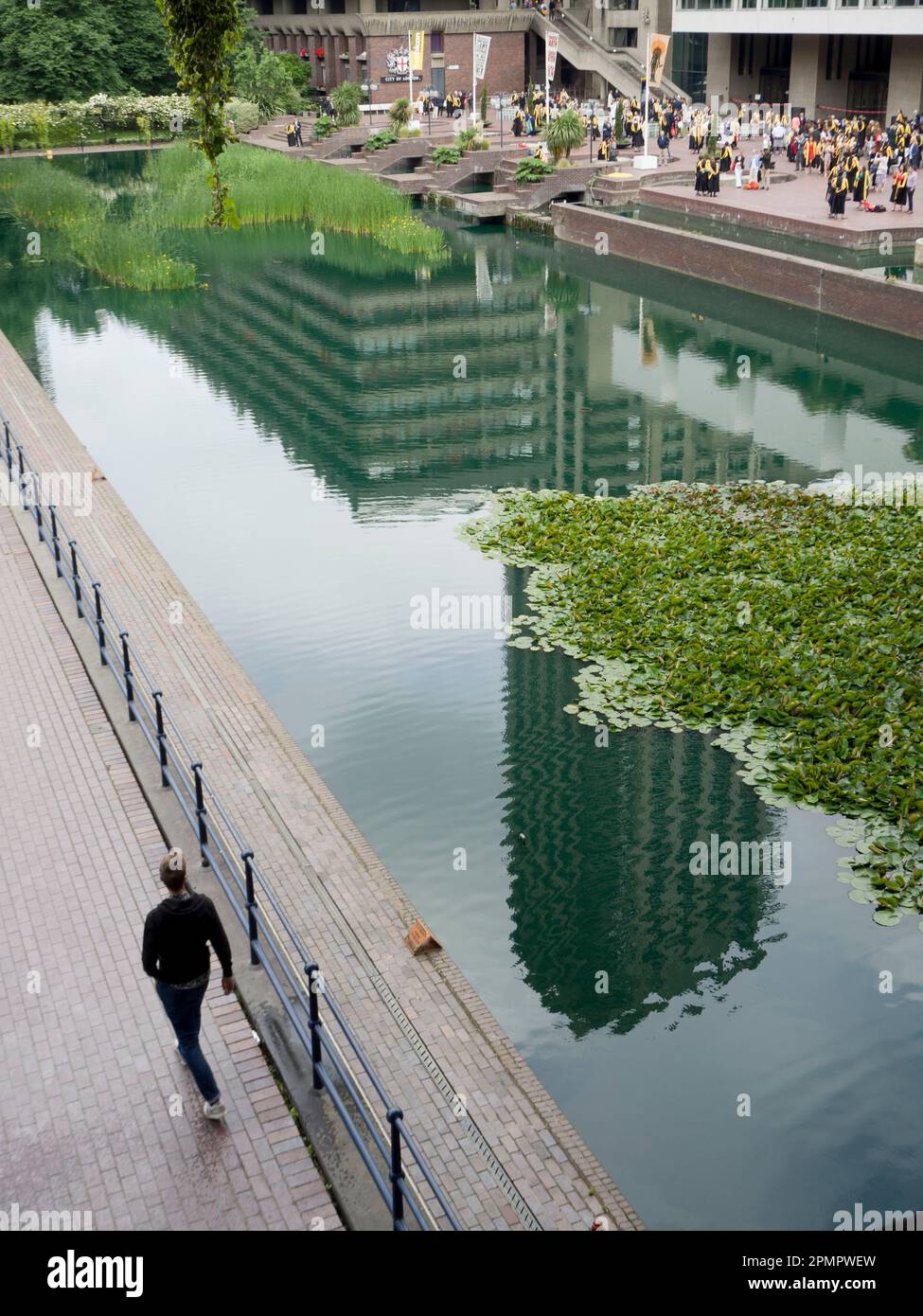 The Barbican Centre, lake with plants, pedestrian walkways and ...