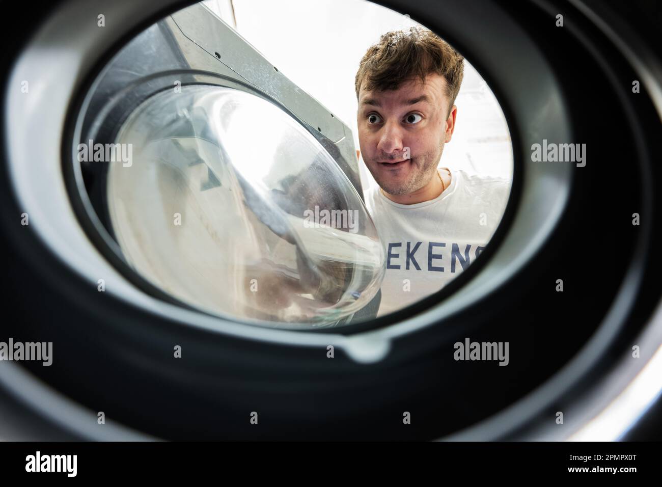 Man view from washing machine inside. Male does laundry daily routine ...