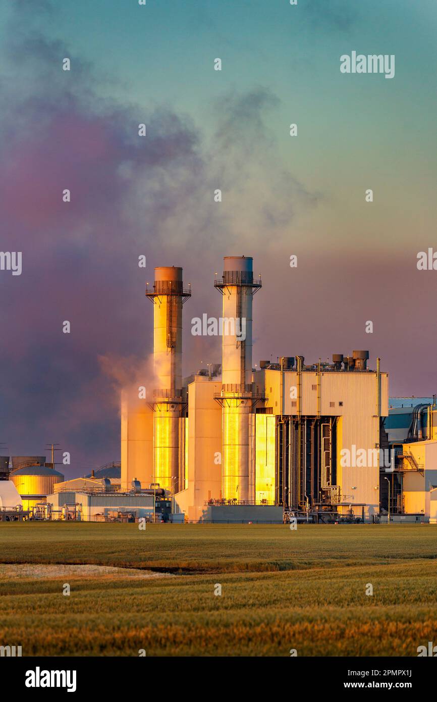 Electrical generating plant reflecting with warm light at sunrise ...