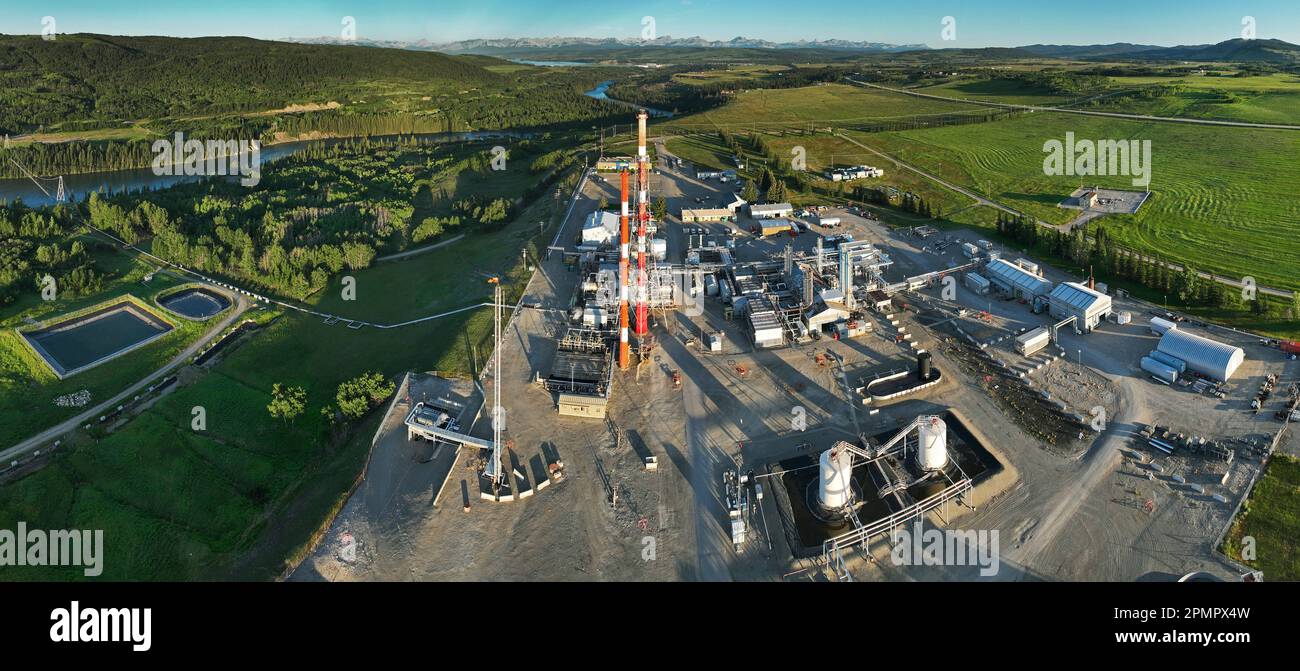 Aerial view of gas plant with striped red and white towers along a ...